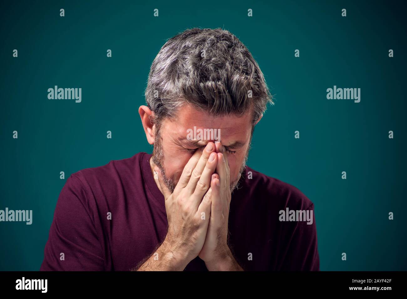 A portrait of sad bearded man in red t-shirt. People and emotions ...