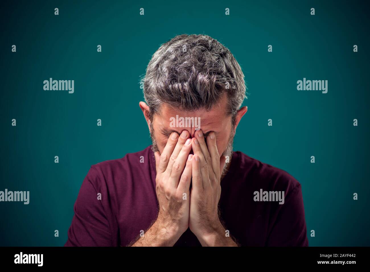A portrait of sad bearded man in red t-shirt. People and emotions ...
