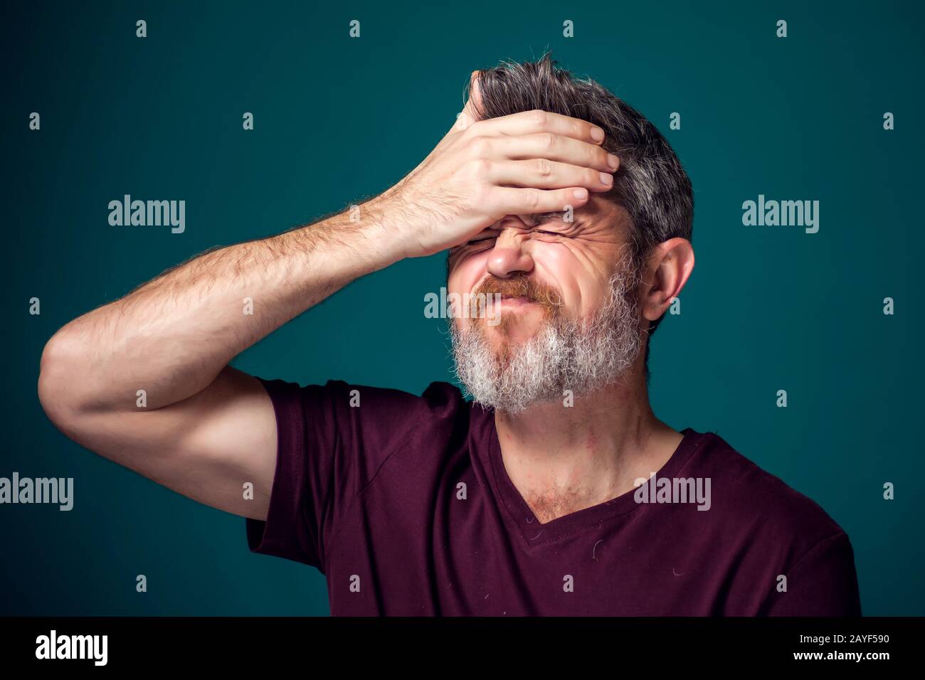 A portrait of sad bearded man in red t-shirt. People and emotions ...