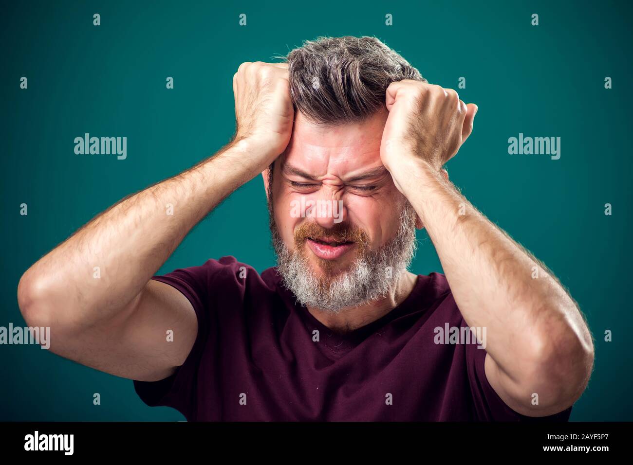 A portrait of sad bearded man in red t-shirt. People and emotions ...