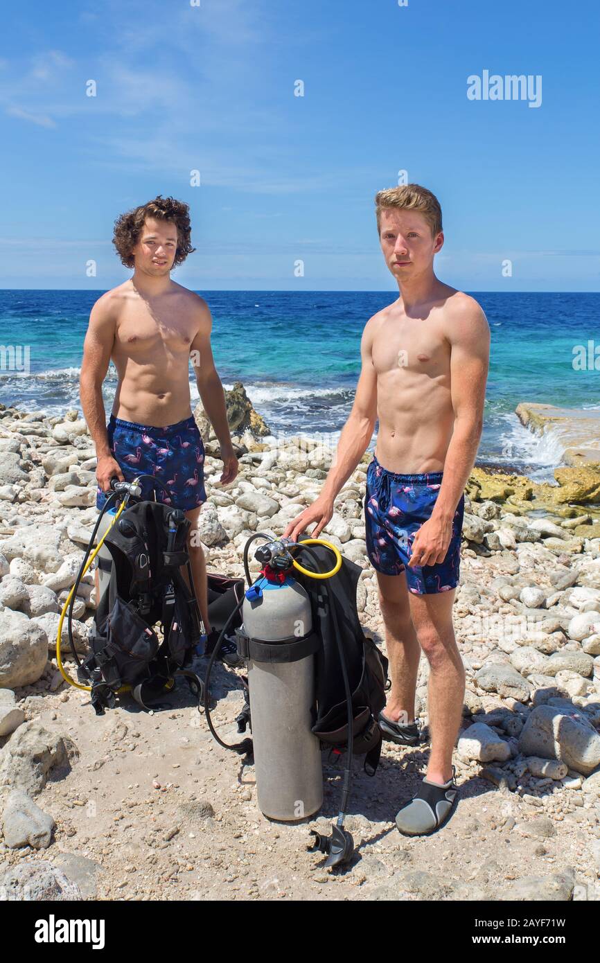 Two divers with diving equipment on beach Stock Photo - Alamy