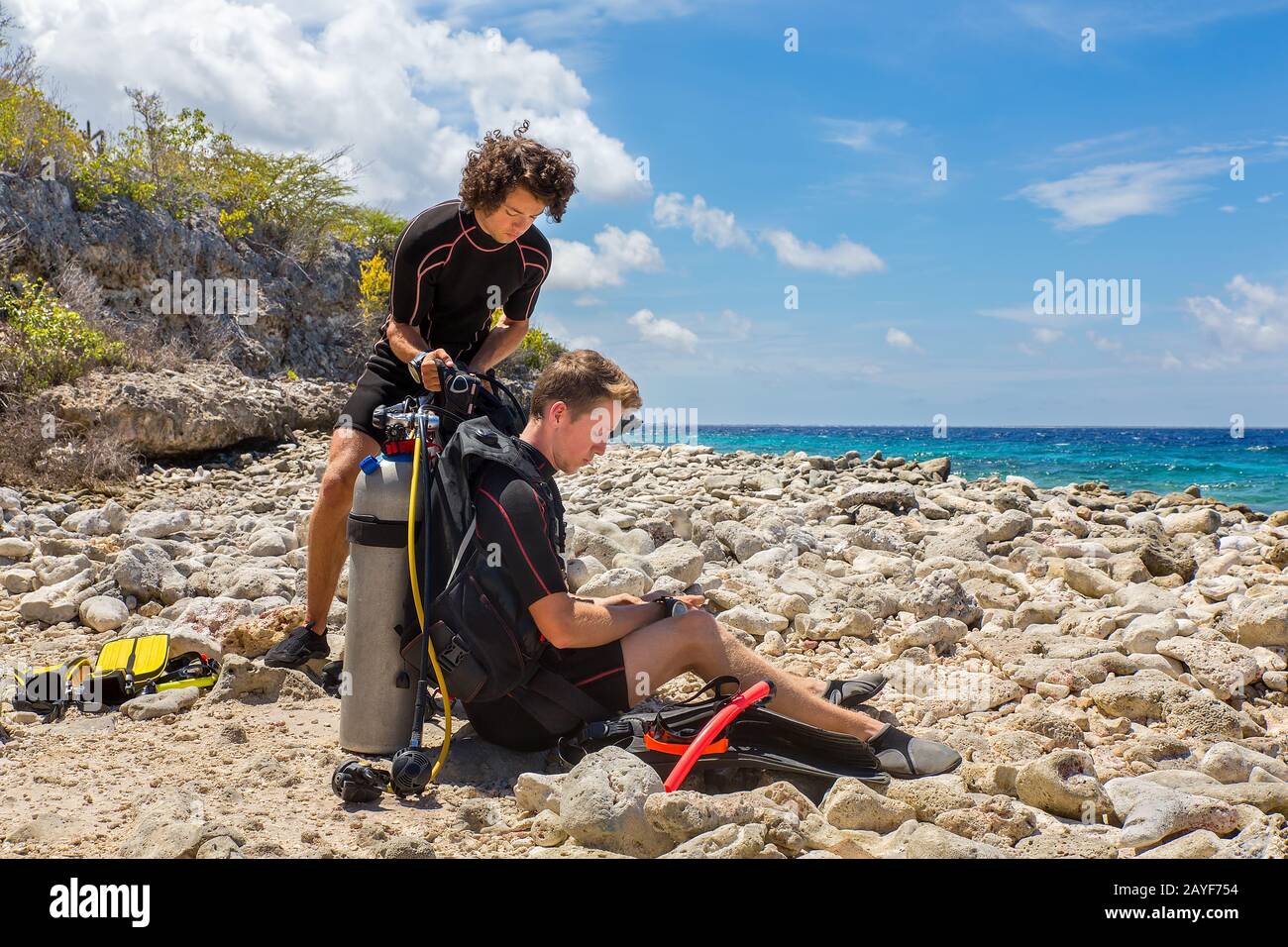 Two divers on the beach get ready for diving Stock Photo - Alamy
