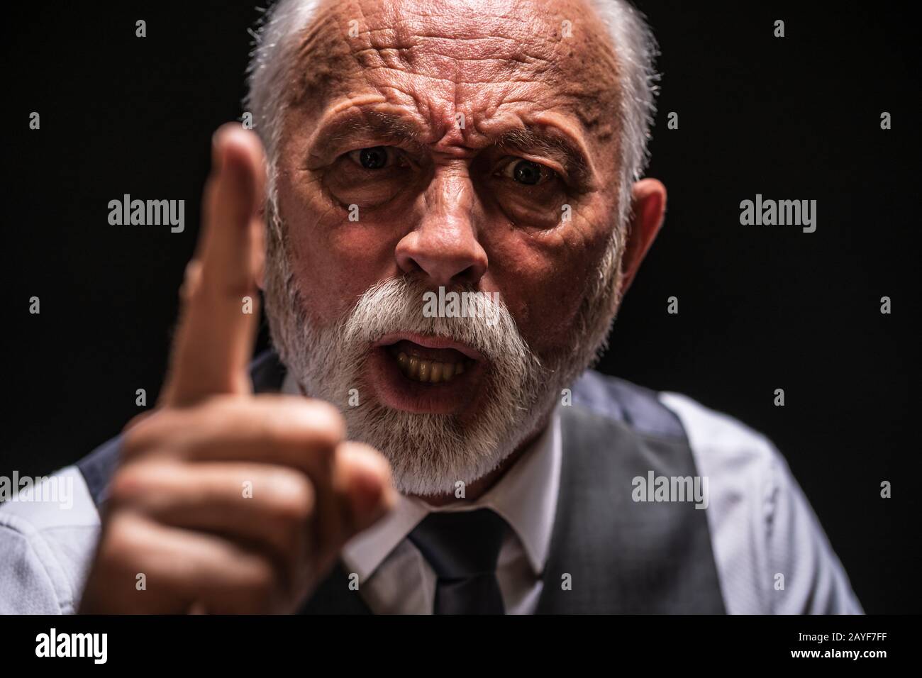 Portrait of angry senior man who threatens. Black background Stock ...