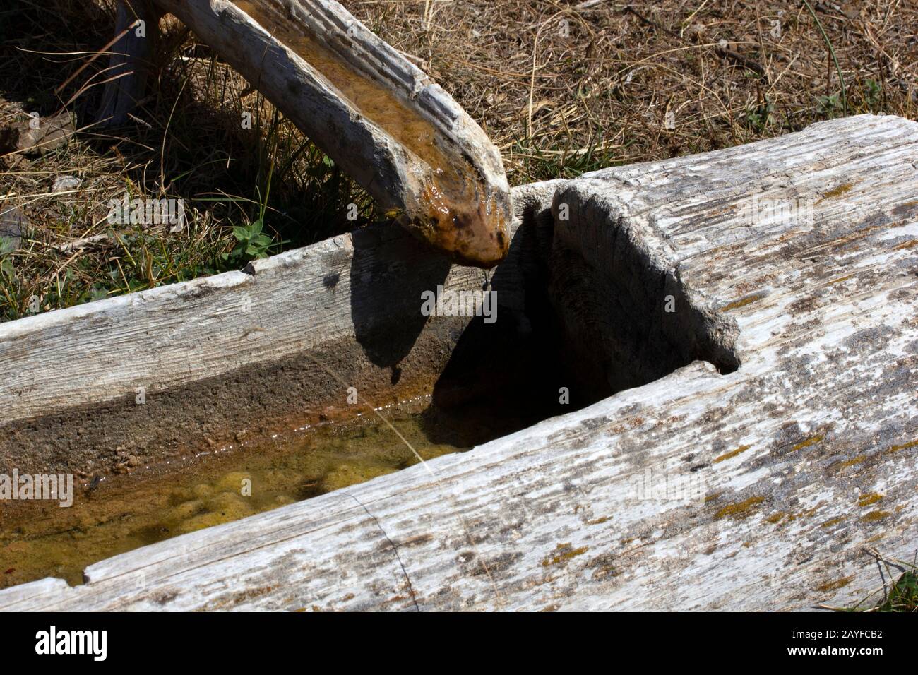 Handmade tree trough. Natural mountain waters Stock Photo - Alamy