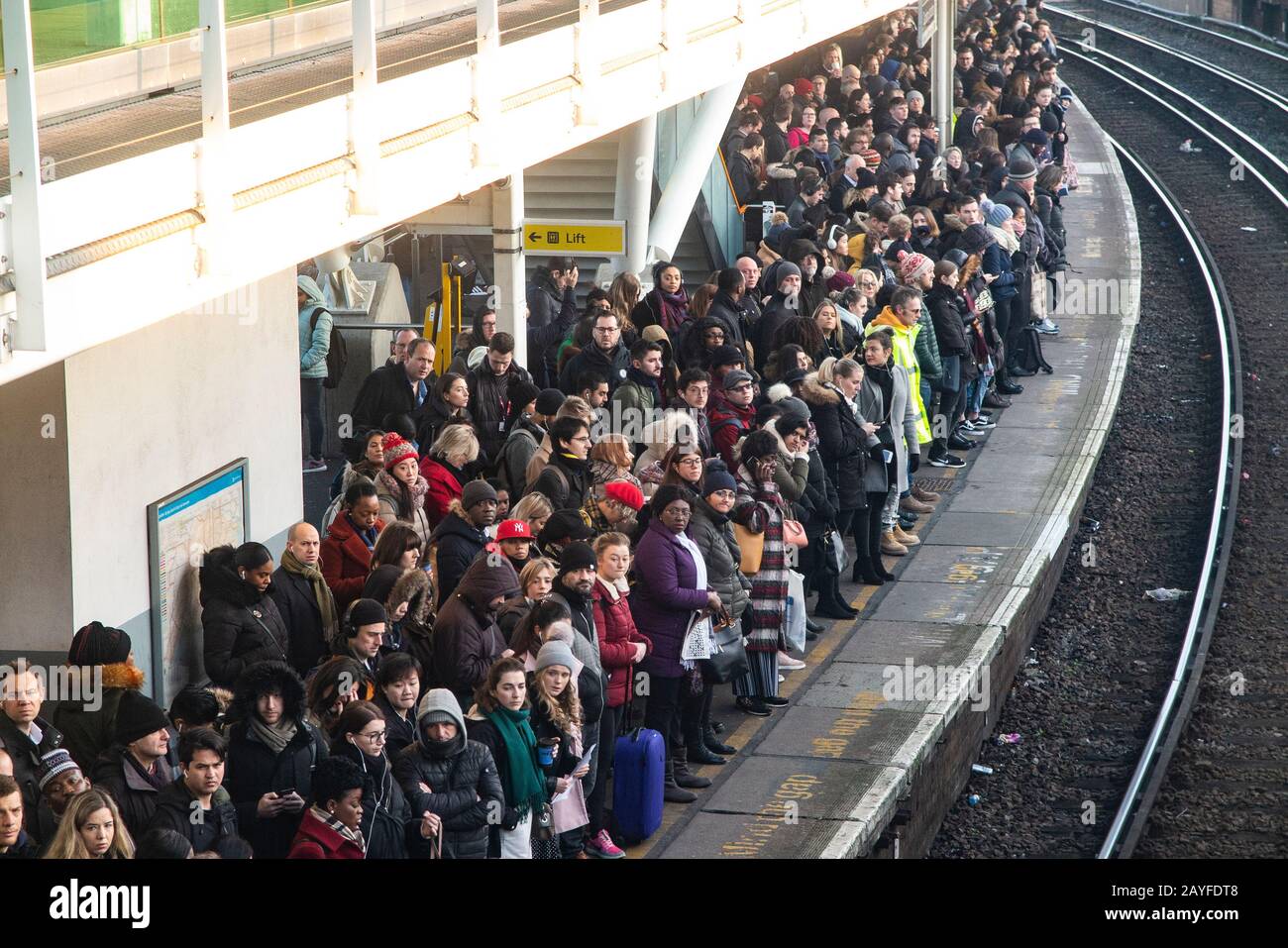 A very crowded platform with commuters trying to find room on a train ...