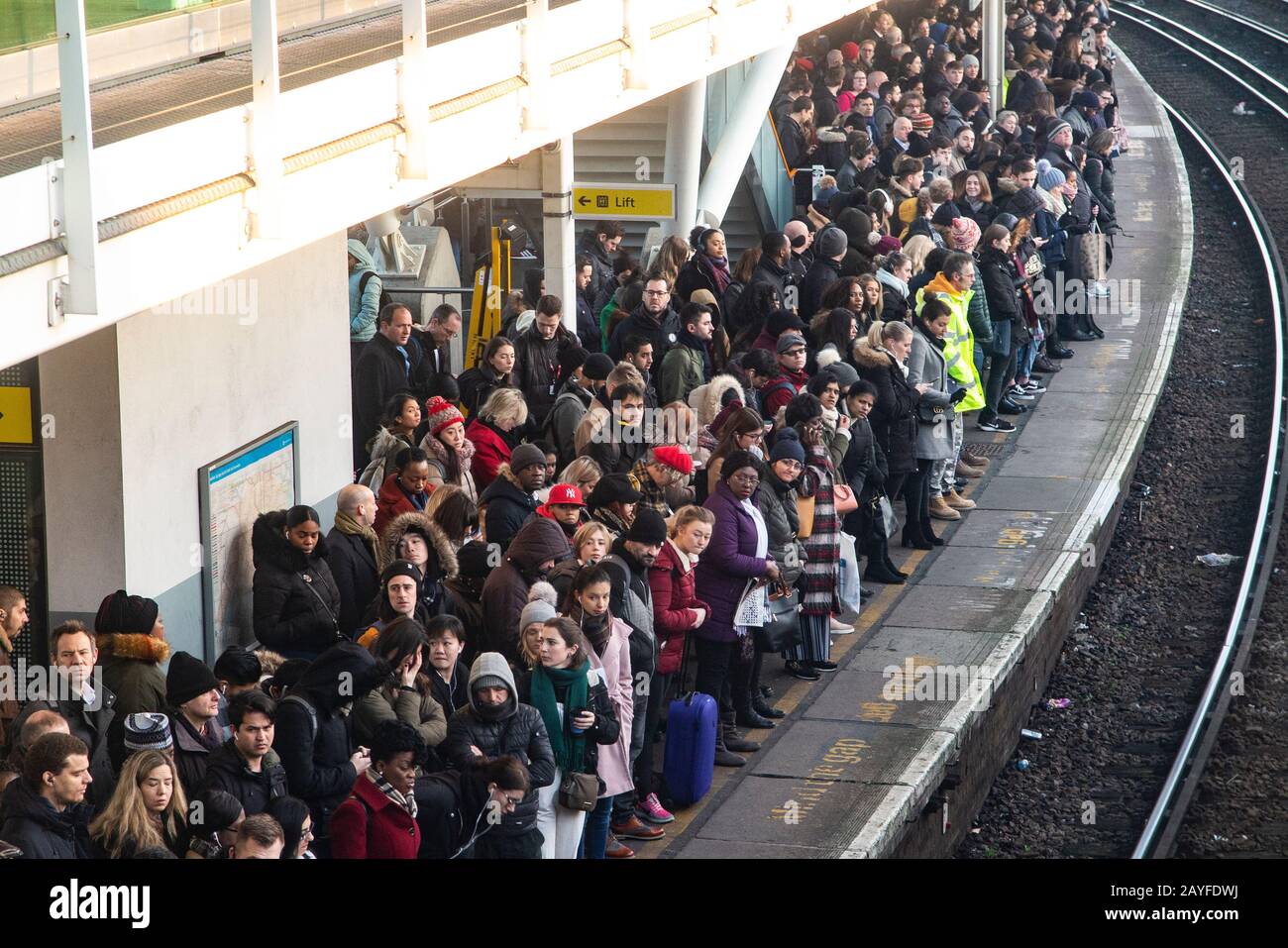 A very crowded platform with commuters trying to find room on a train ...
