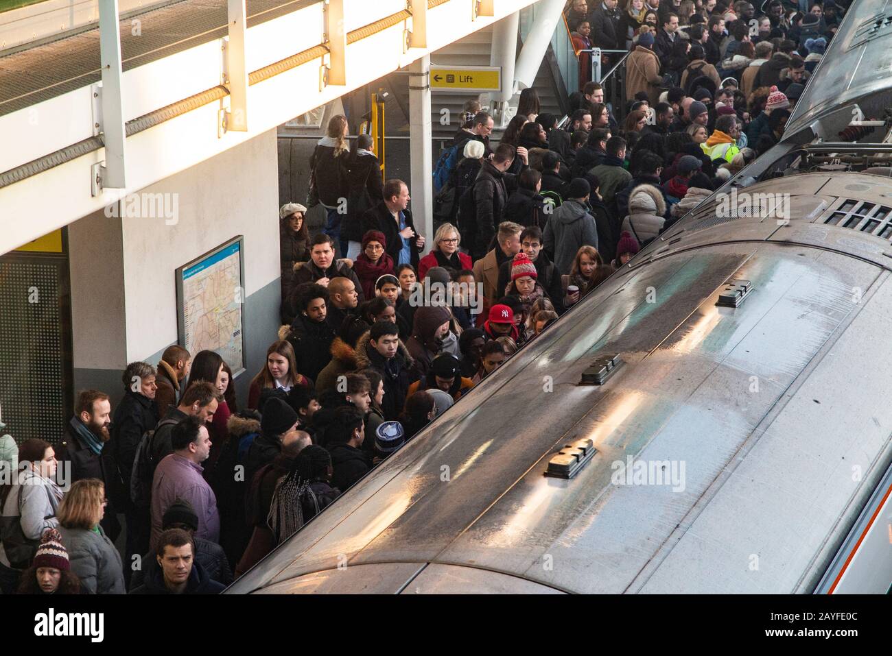 A very crowded platform with commuters trying to find room on a train ...
