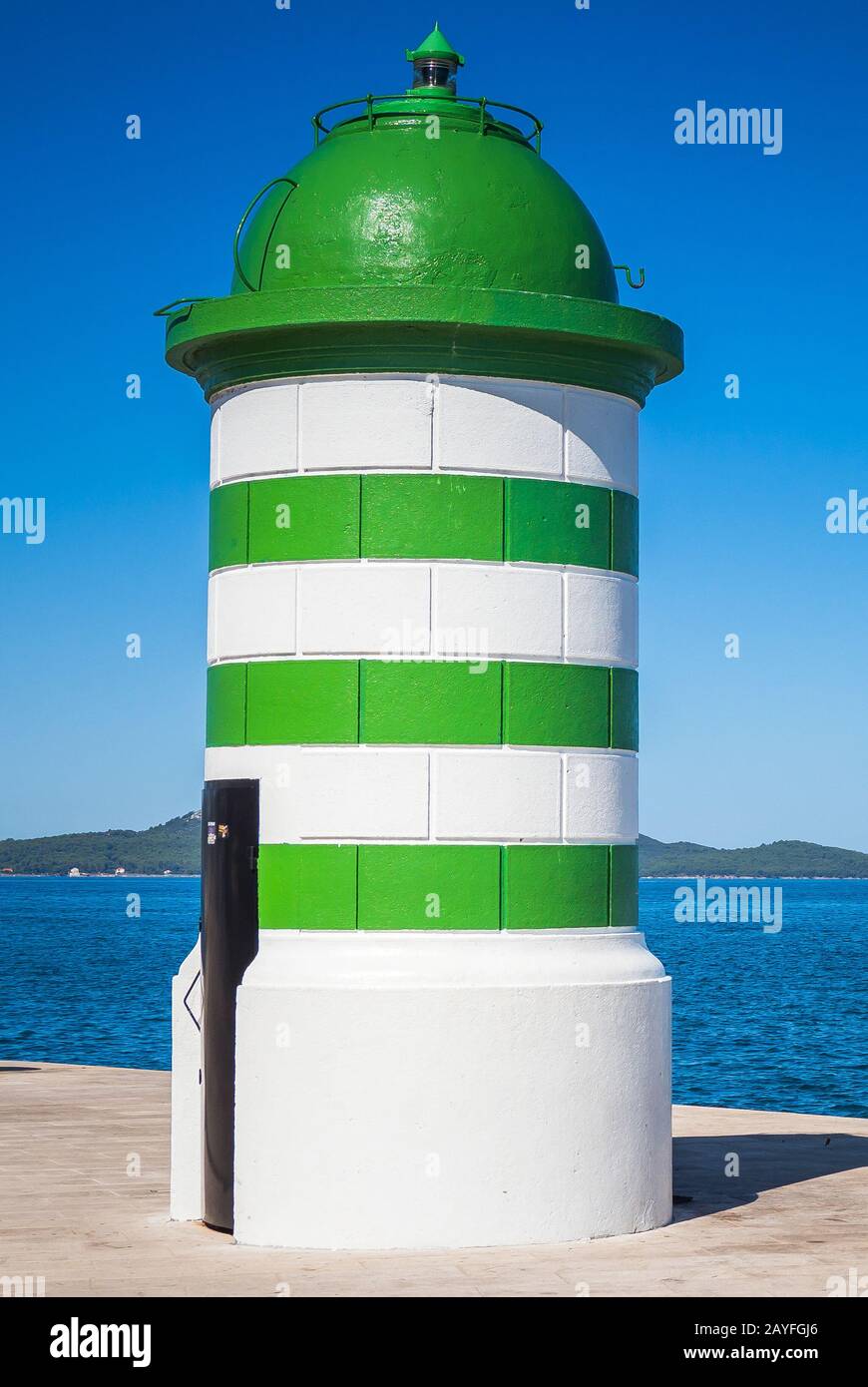 Closeup view of green and white striped lighthouse building, vertical ...