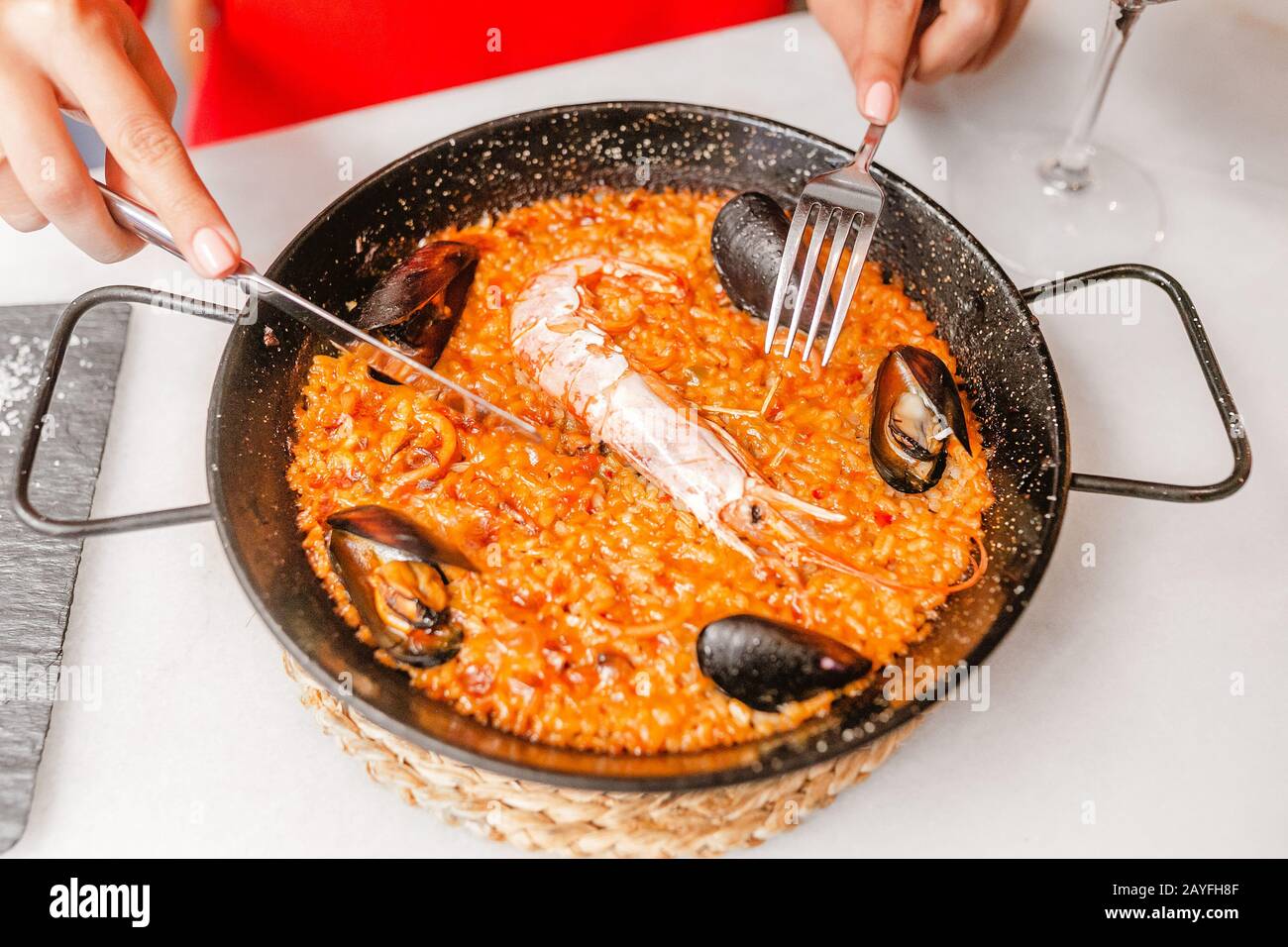 Woman eating black paella seafood hi-res stock photography and images ...
