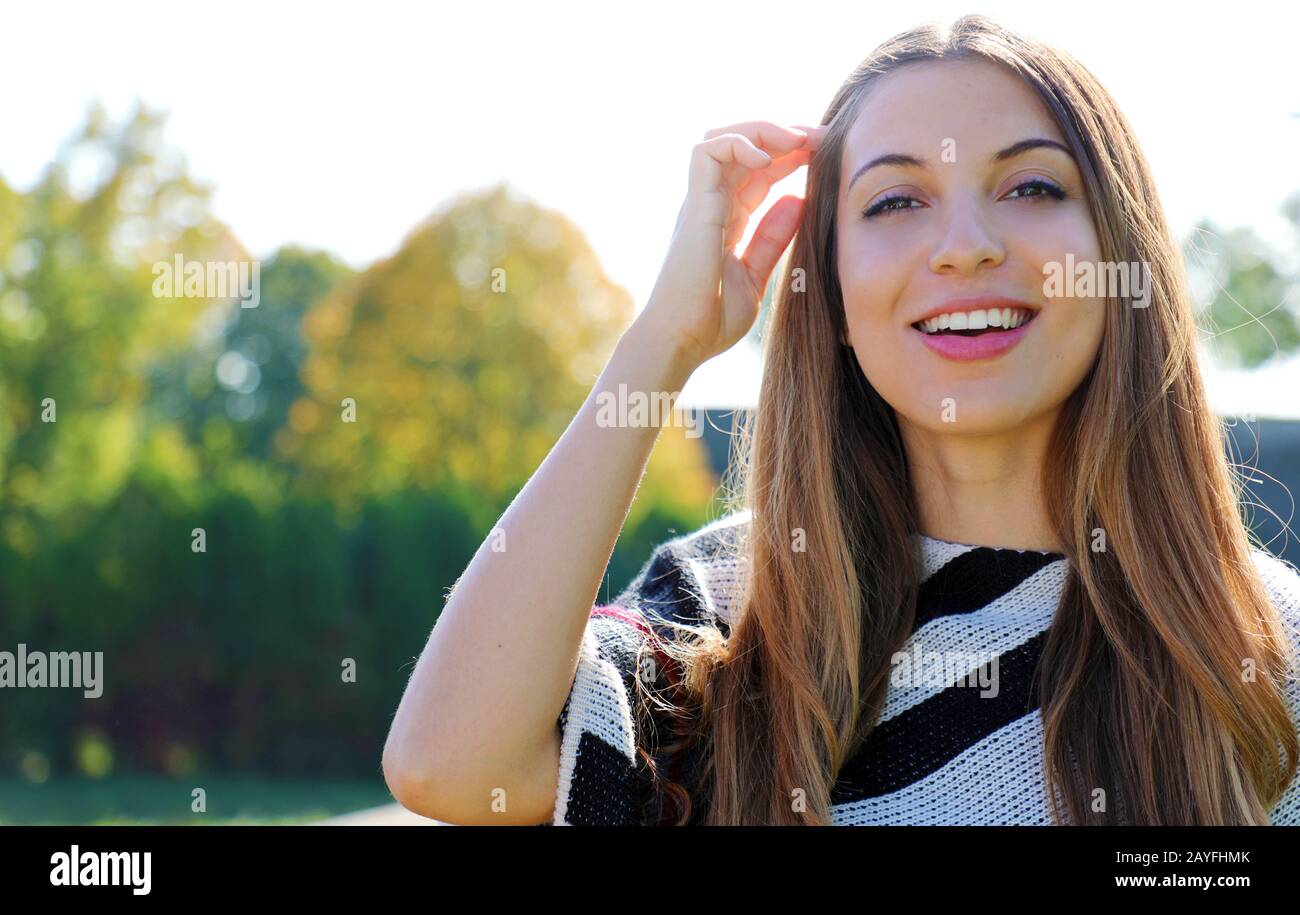 Close up of young smiling woman outdoor looking at camera in spring ...