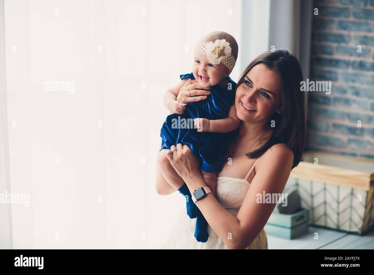 mom holds her lovely child tender standing in a room Stock Photo - Alamy