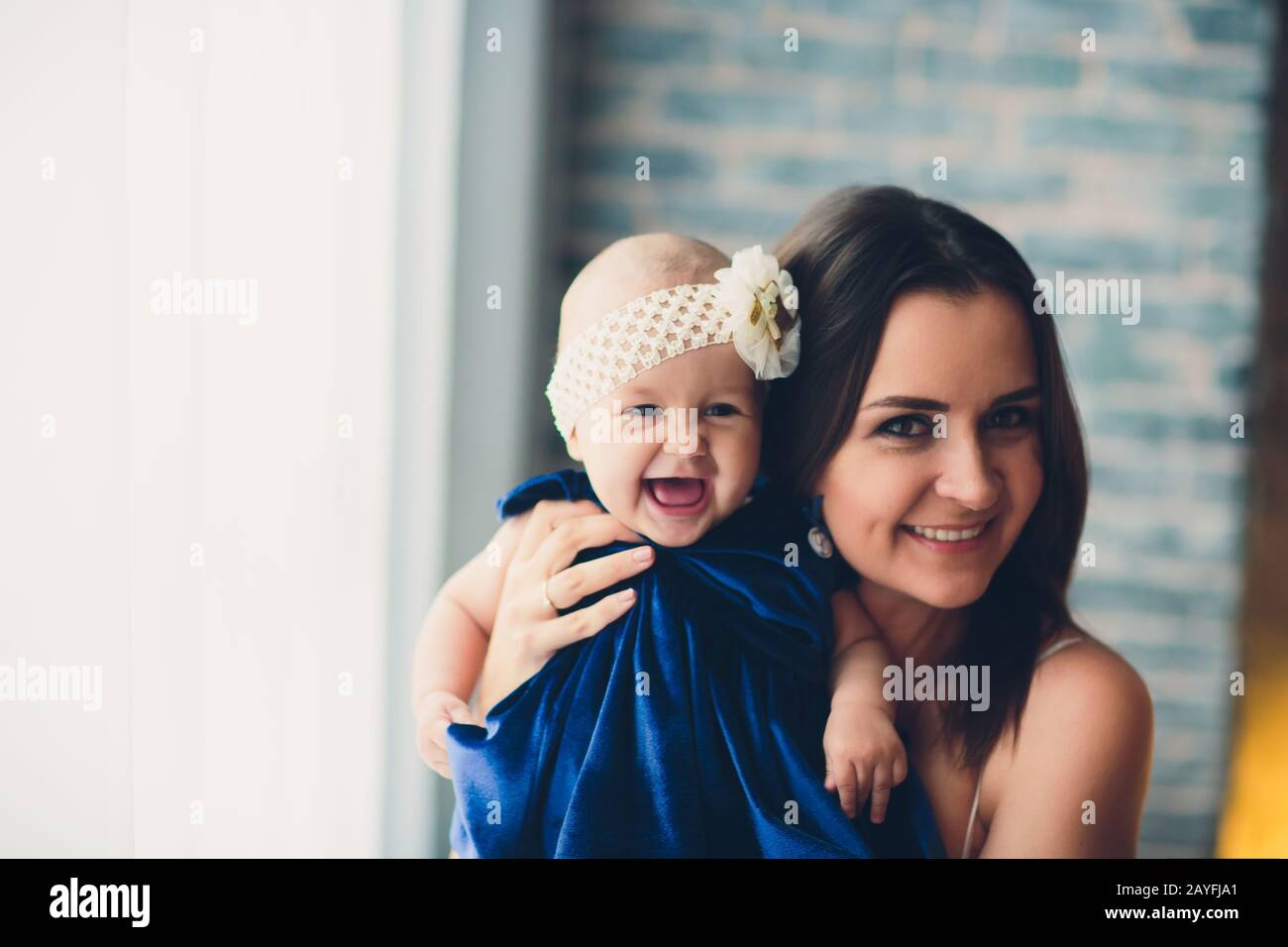 mom holds her lovely child tender standing in a room Stock Photo - Alamy