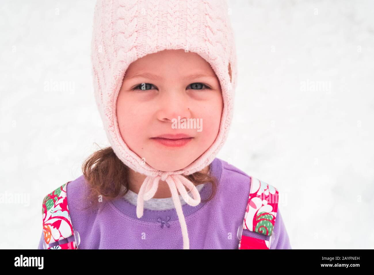 Little girl in pink hat playing in snow Stock Photo - Alamy