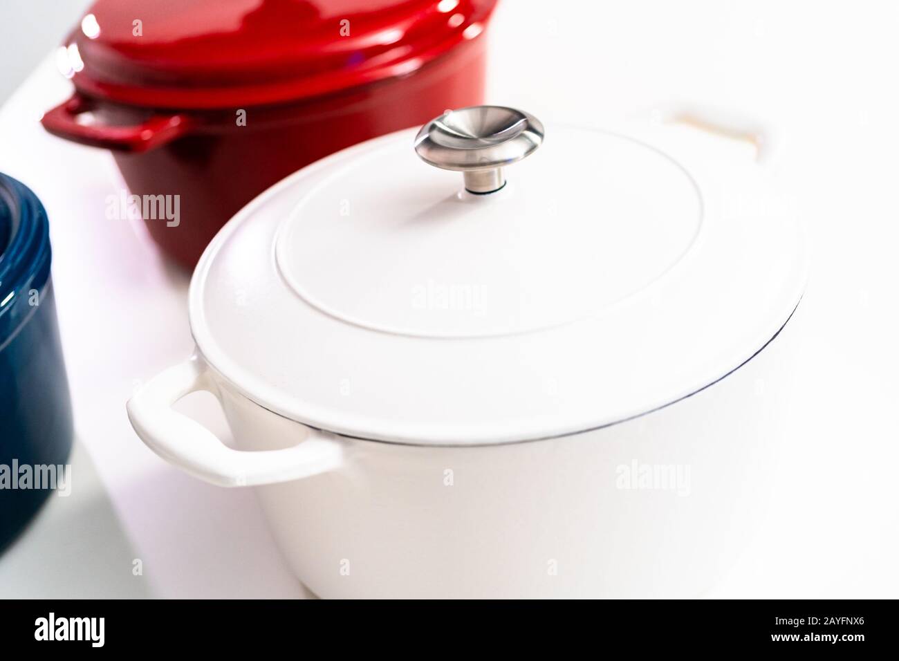 Red, white and blue enameled cast iron covered round dutch ovens on a ...