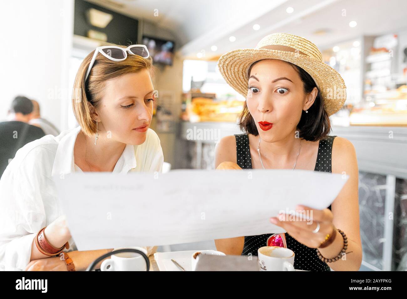 Shocked and surprised girlfriend girlfriend looking at the menu in the ...