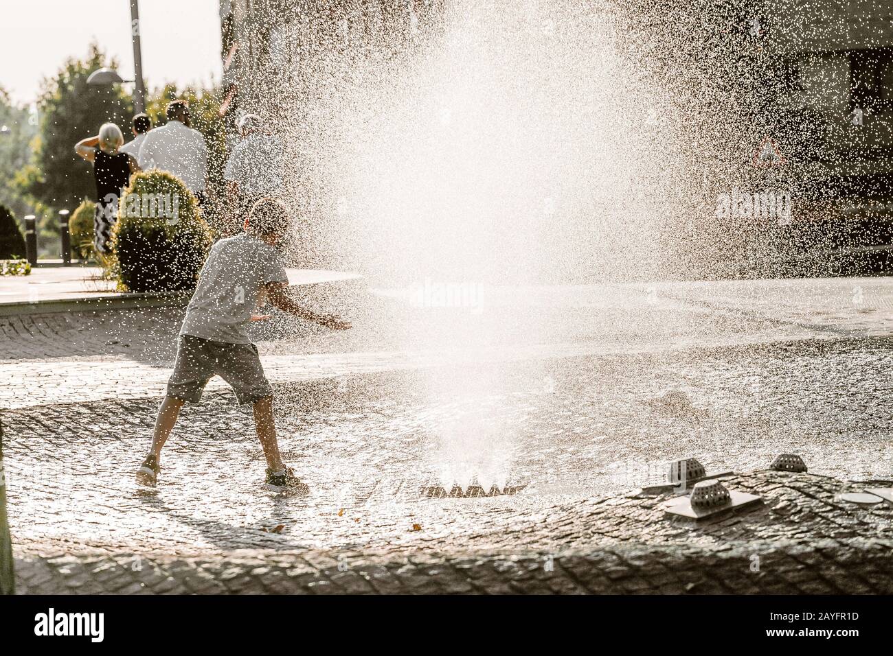 kid jumping and having fun in city fountain Stock Photo - Alamy