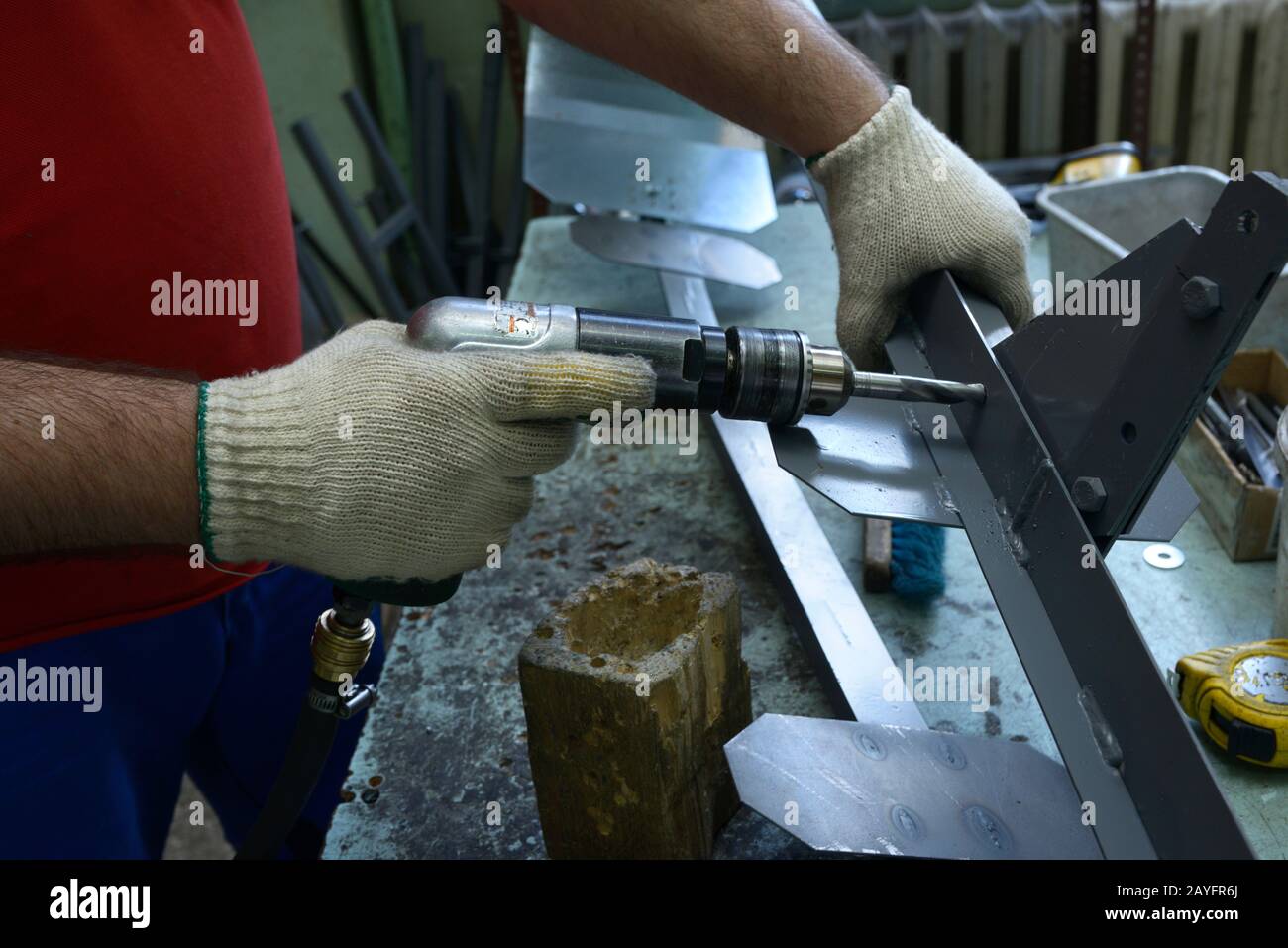 Fitter hands working with a pistol type pneumatic drill preparing the ...