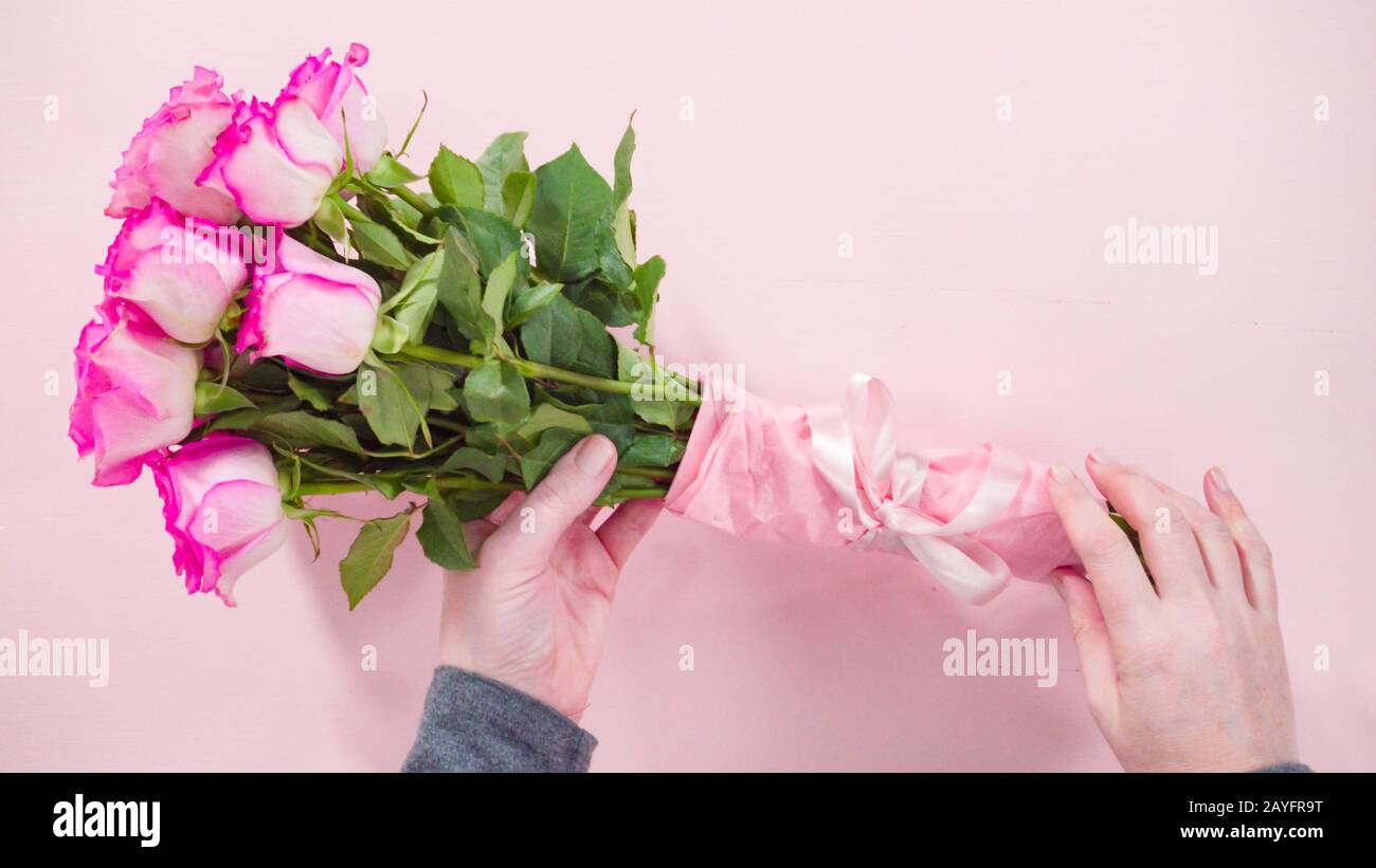 Flat lay. Step by step. Florist arranging a bouquet from pink roses ...
