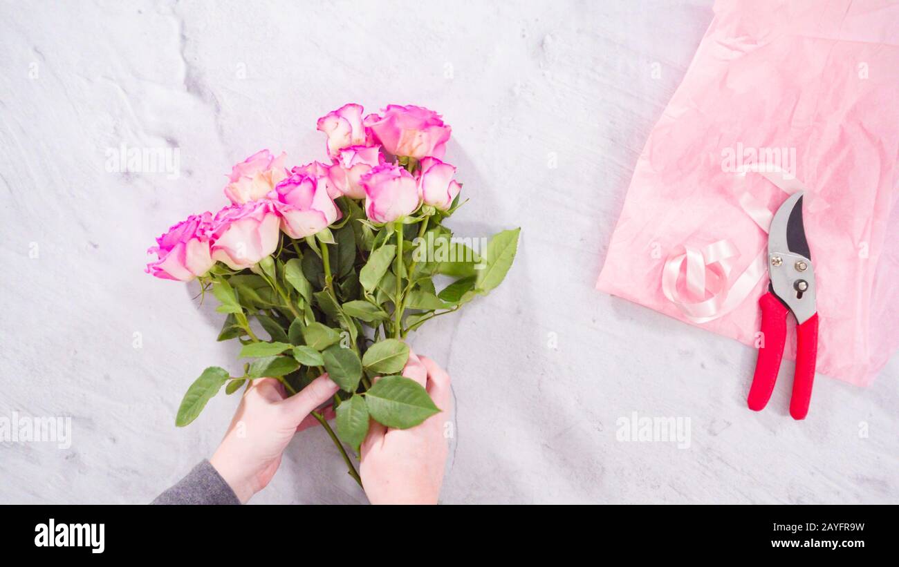 Flat lay. Step by step. Florist arranging a bouquet from pink roses ...