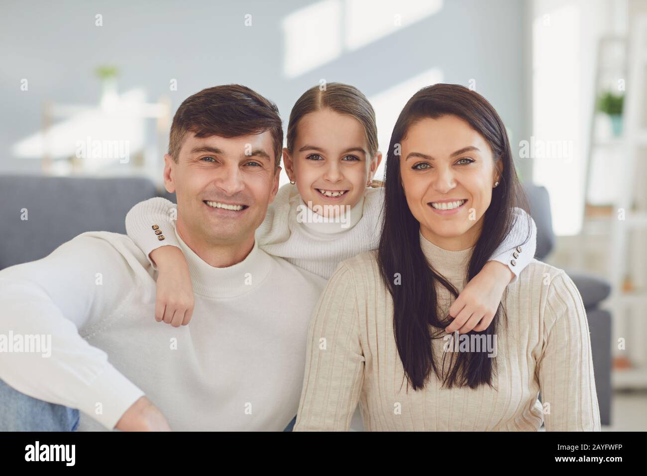 Happy smiling family. Daughter mother and father smiling hugging ...