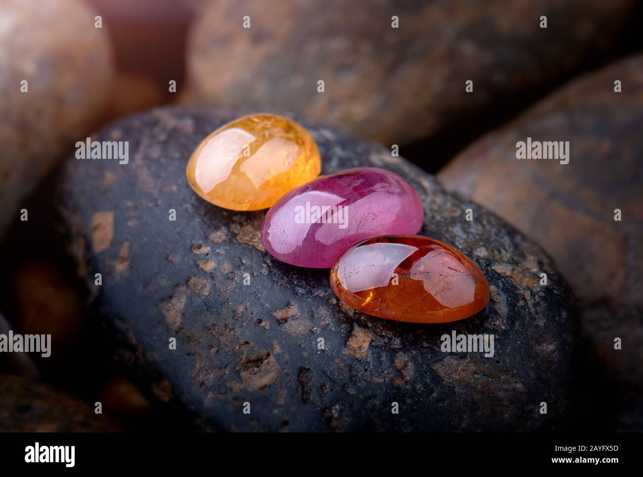 Round cut mineral gemstones with dark stones background Stock Photo - Alamy