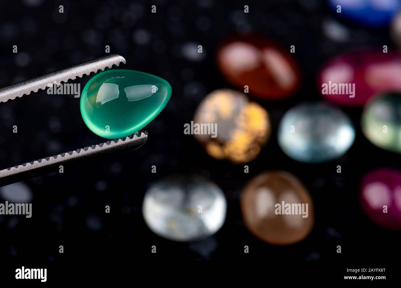 Round cut emerald mineral gemstone with dark stones background Stock ...