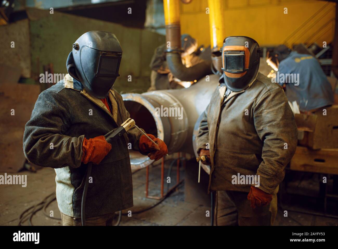 Two welder in masks prepares to work with metal Stock Photo - Alamy