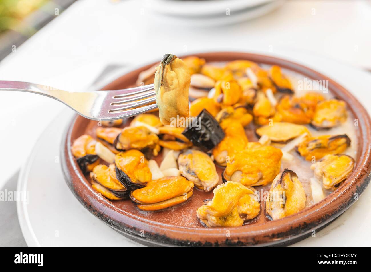 Woman eating shellfish mussels in seafood restaurant Stock Photo - Alamy