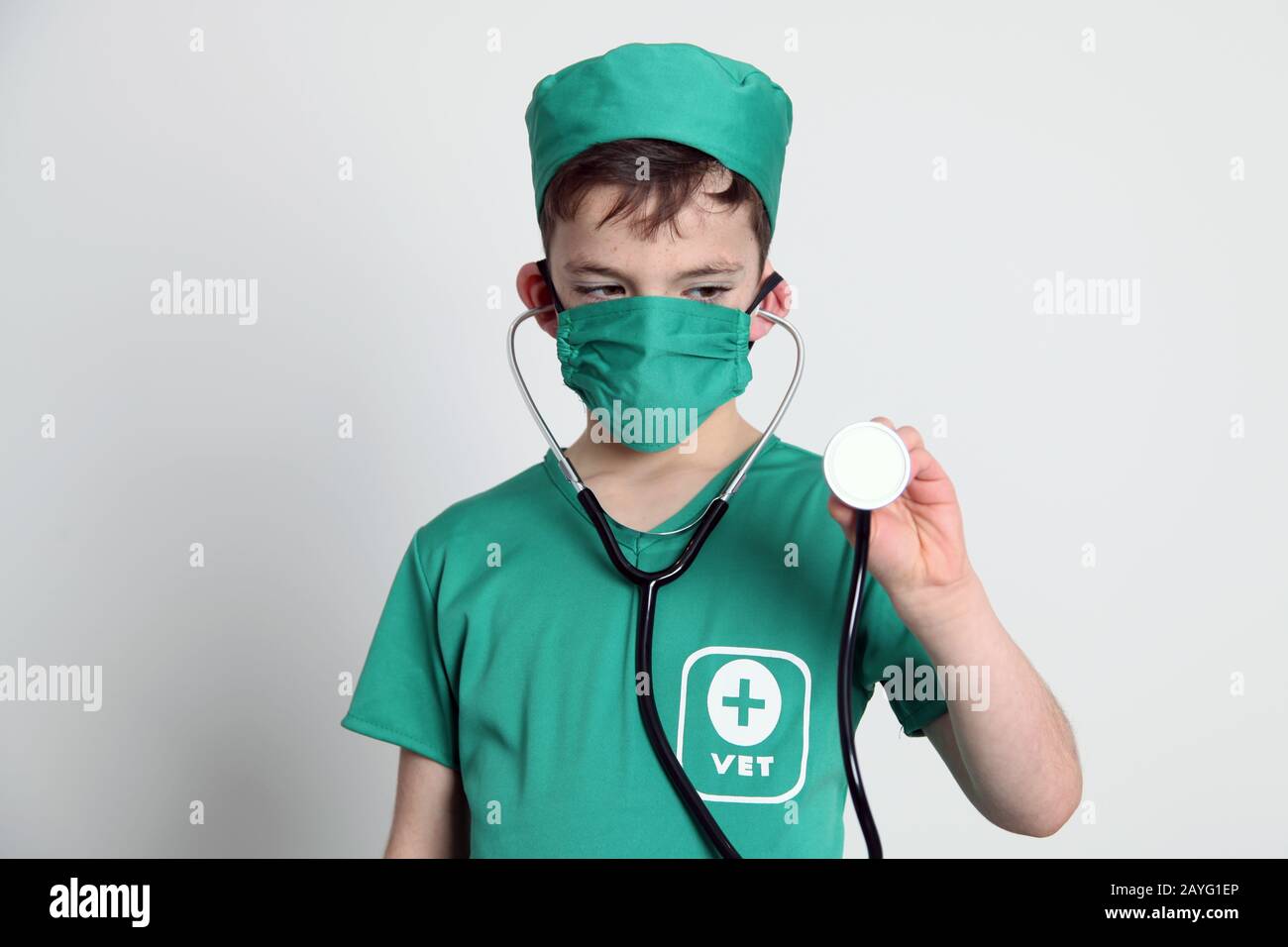A young child 8yr old boy dressed as a vet with stethoscope on white ...