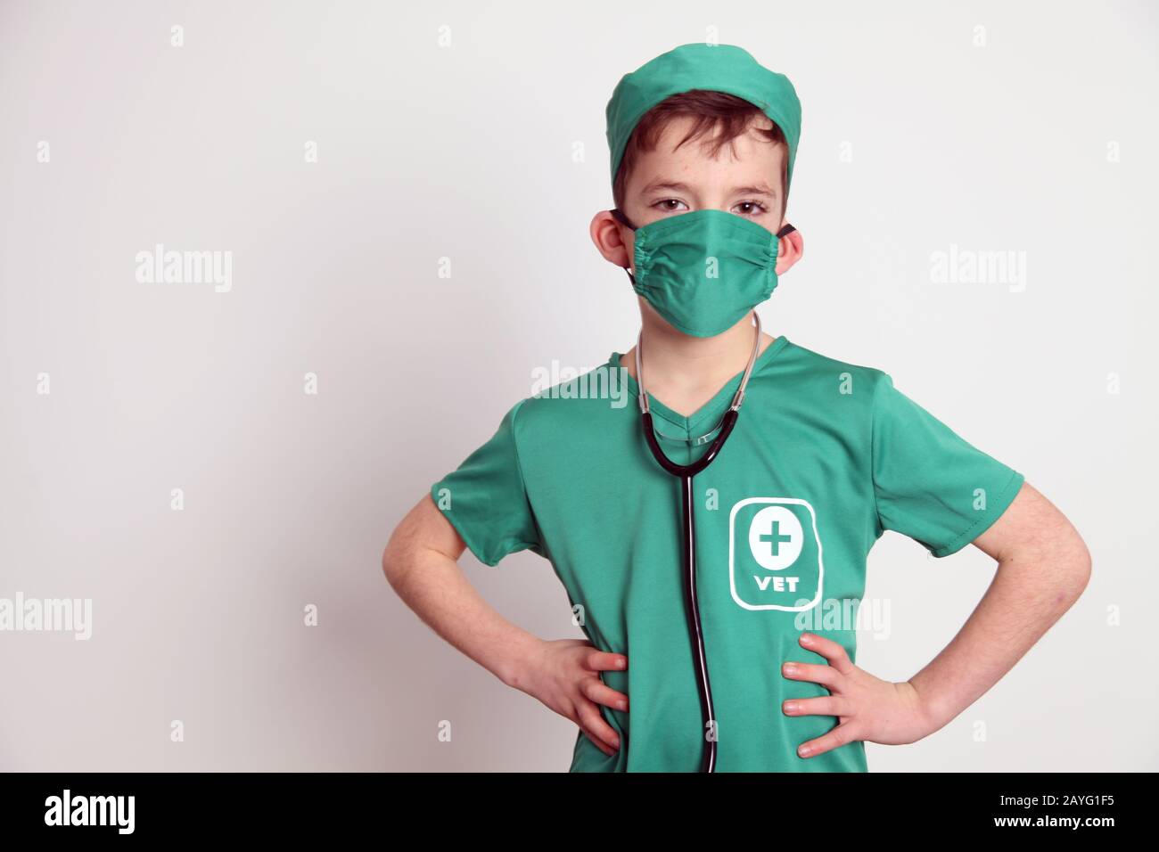 A young child 8yr old boy dressed as a vet with stethoscope on white ...