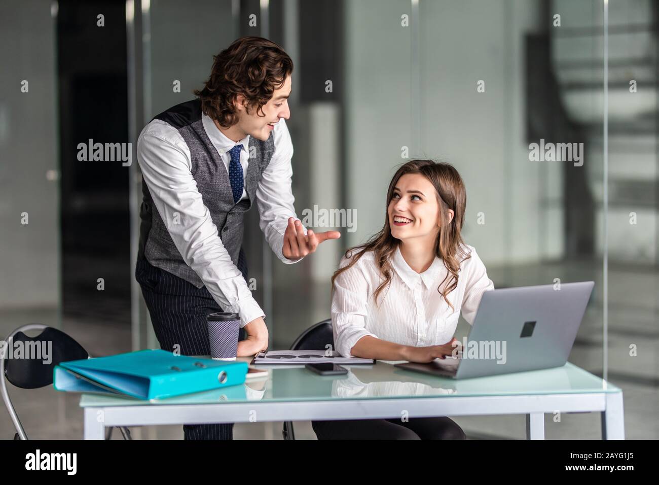 Two colleagues using laptop in office Stock Photo - Alamy