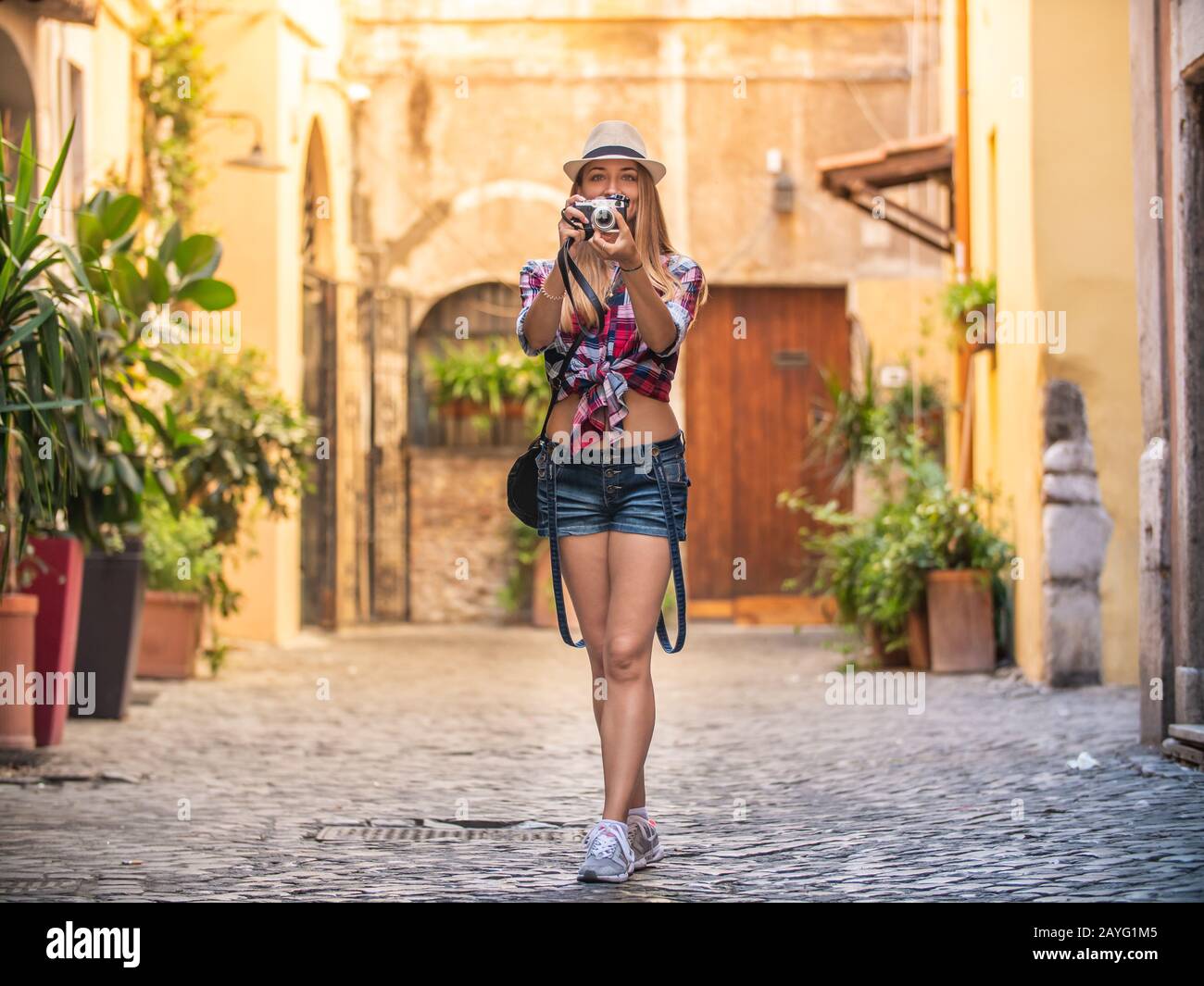 Young blonde woman with blue eyes taking pictures with vintage camera ...