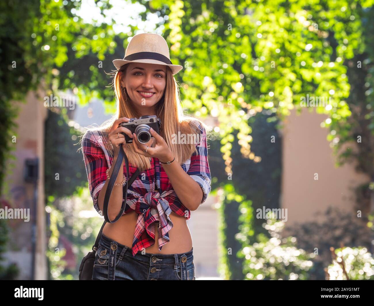 Young blonde woman with blue eyes taking pictures with vintage camera ...