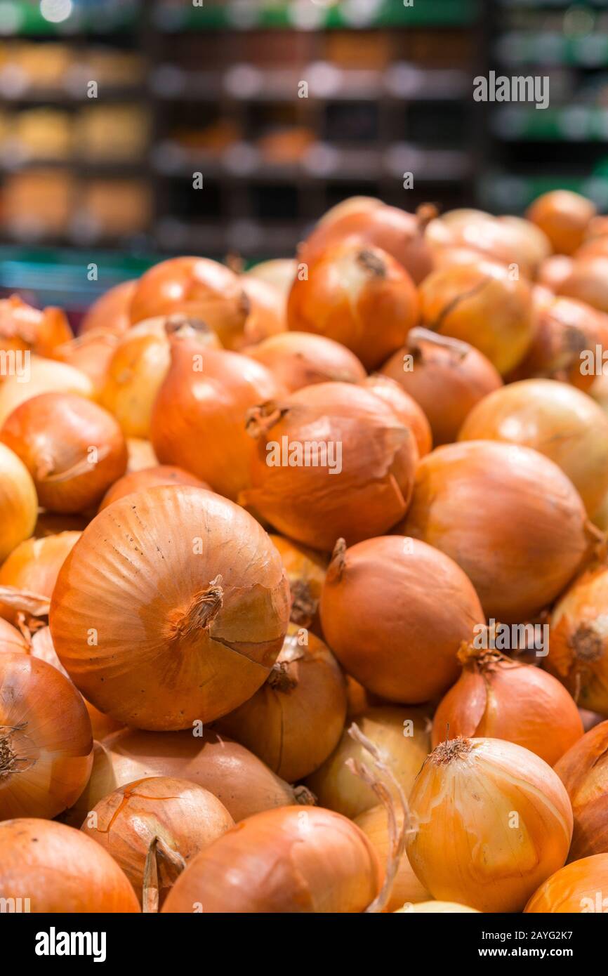 Fresh yellow onions as a background. Vegetable store. Yellow onion lies ...
