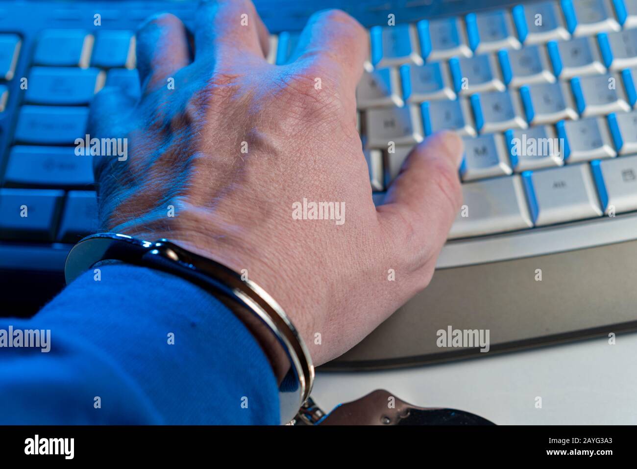 Hand of a man in handcuffs on a background of a computer keyboard Stock ...