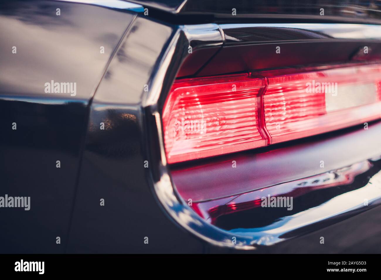 Detail of red metallized black rear car headlight in eye shape, with ...