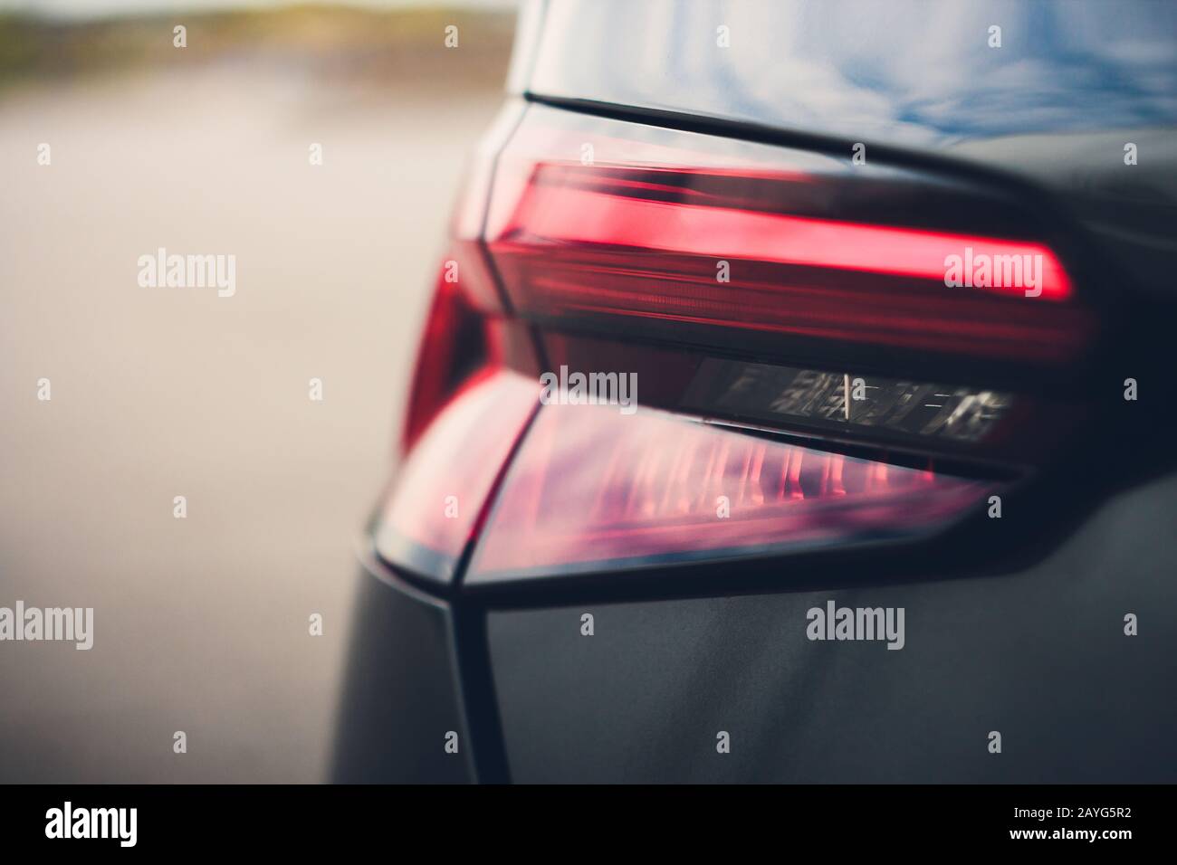 Detail of red metallized black rear car headlight in eye shape, with ...