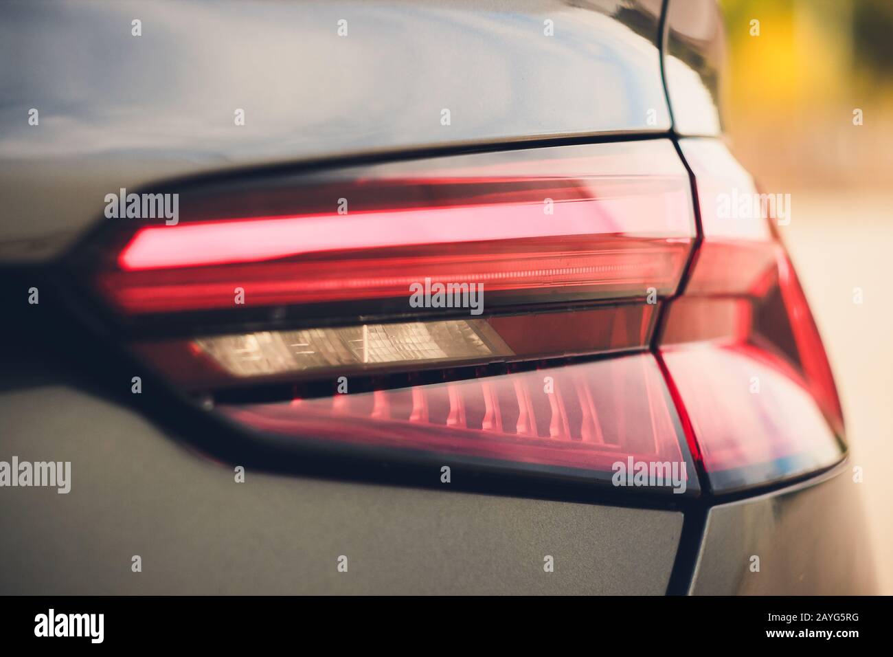 Detail of red metallized black rear car headlight in eye shape, with ...