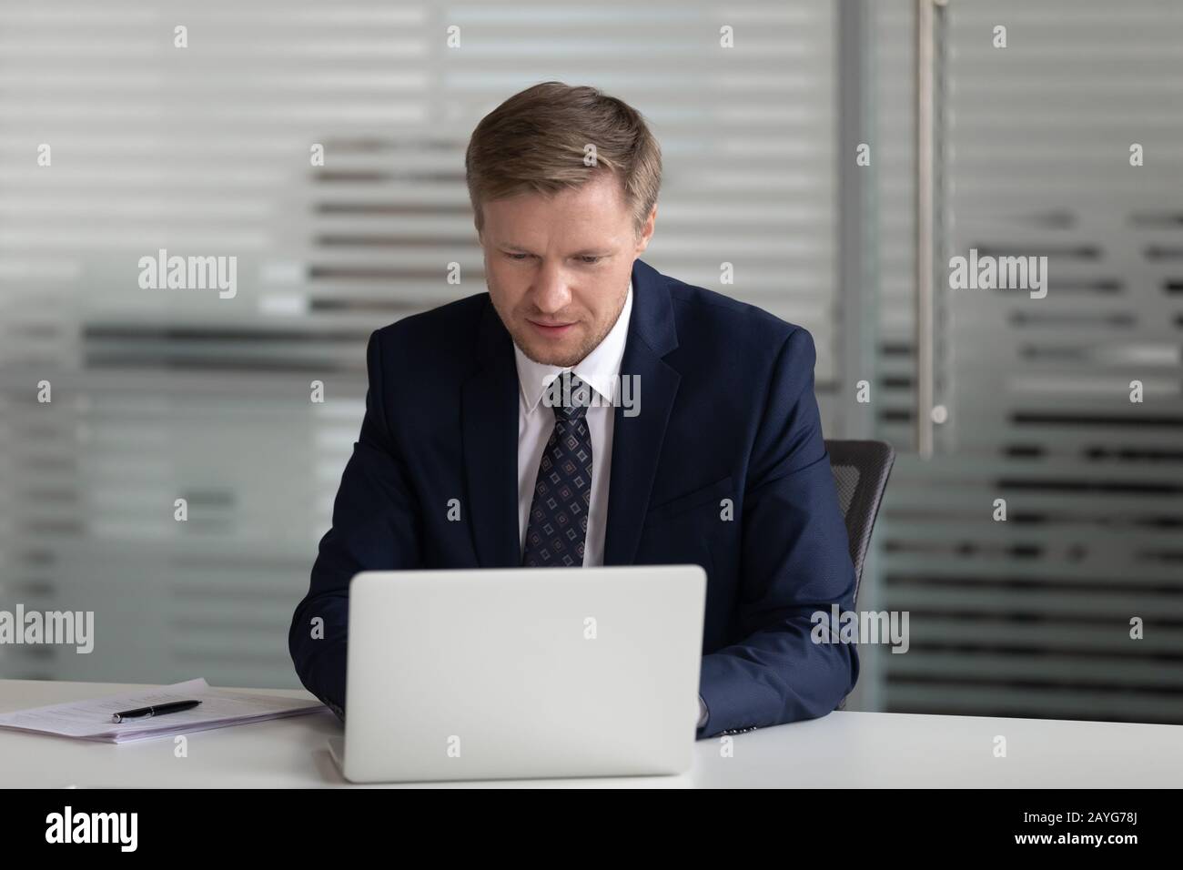 Focused male CEO busy using laptop at workplace Stock Photo - Alamy