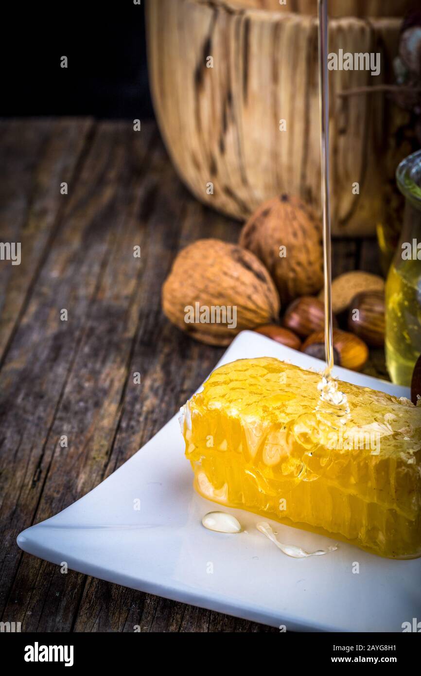 honey dipper and honeycomb, nuts in honey and nuts of various kinds ...