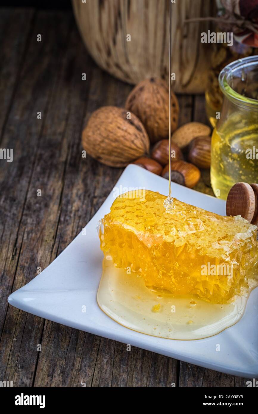 honey dipper and honeycomb, nuts in honey and nuts of various kinds ...