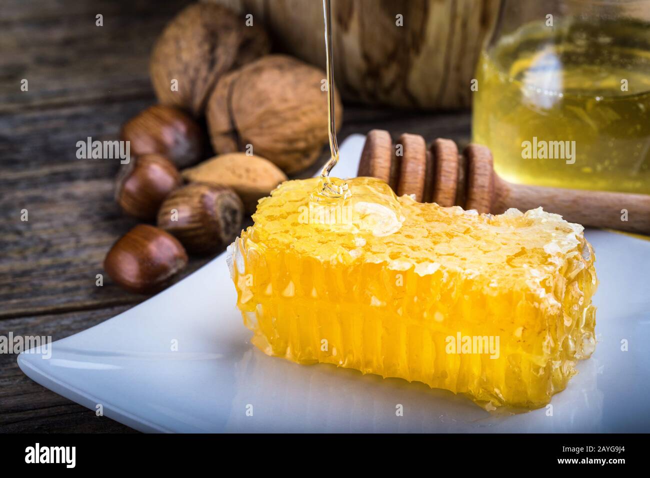honey dipper and honeycomb, nuts in honey and nuts of various kinds ...