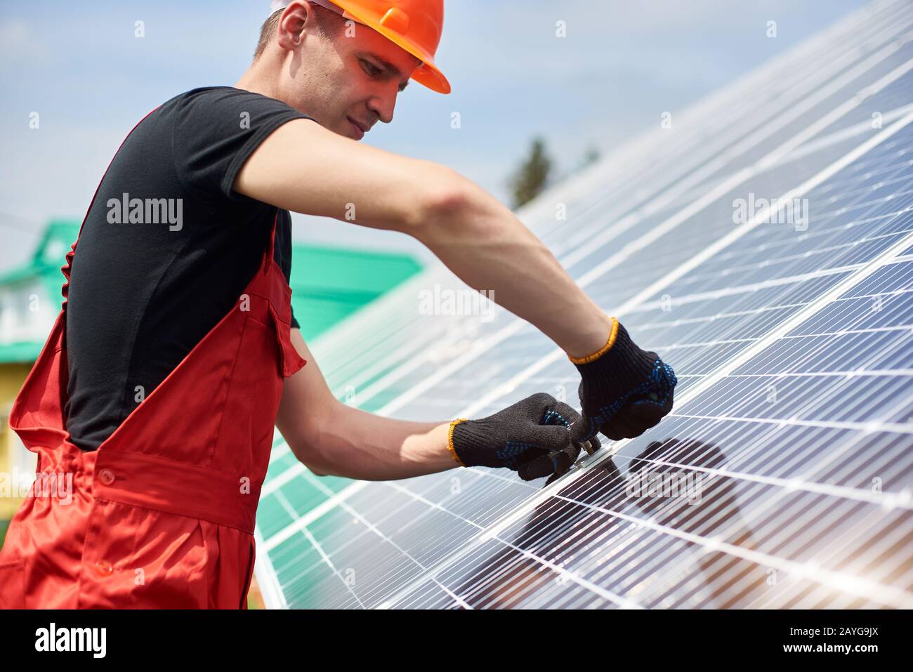Electrician installing solar panels to save energy. A man is wearing an ...