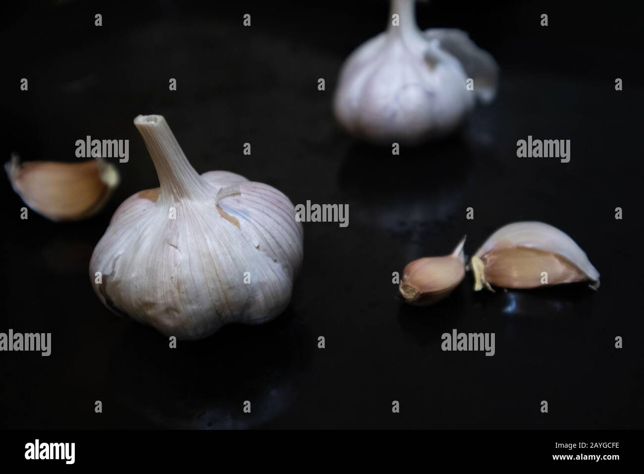 Garlic close-up product show on black background. Spice garlic clove ...