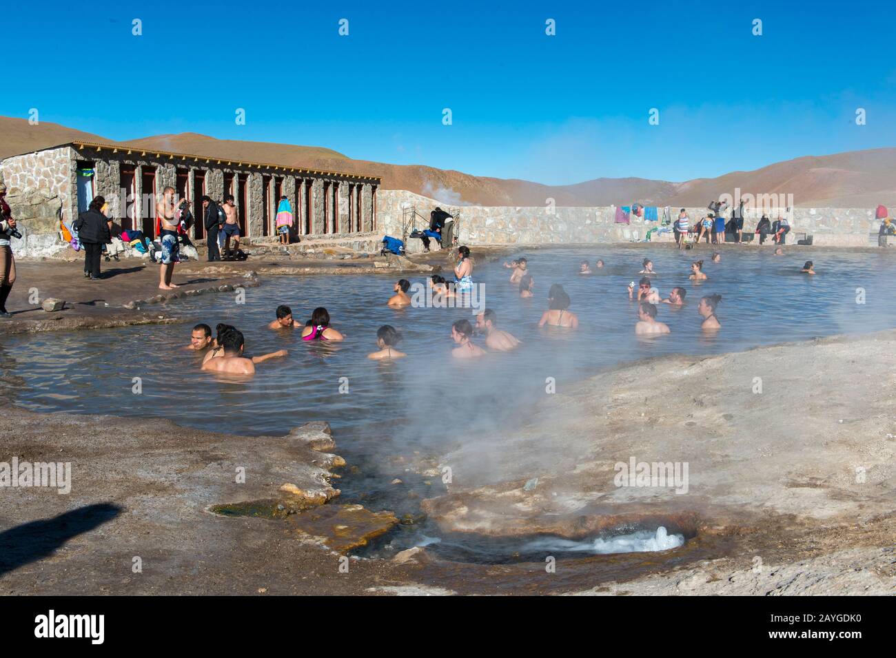 Tourists bathing in hot springs at El Tatio Geysers geothermic basin ...