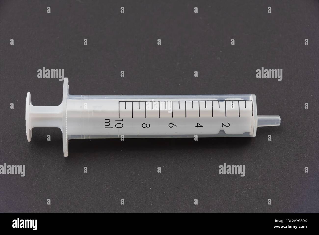 white and clear plastic syringe on a black background Stock Photo - Alamy