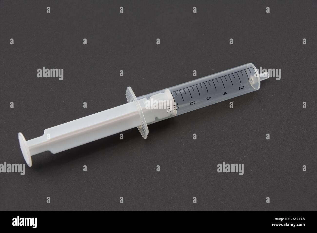 white and clear plastic syringe on a black background Stock Photo - Alamy
