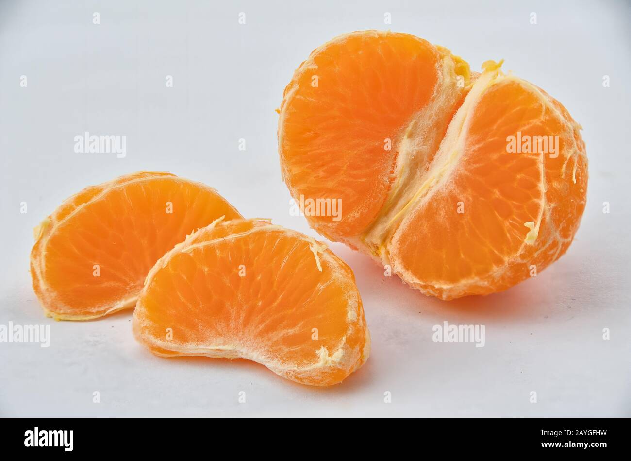 A peeled and segmented clementine fruit on a white background Stock ...