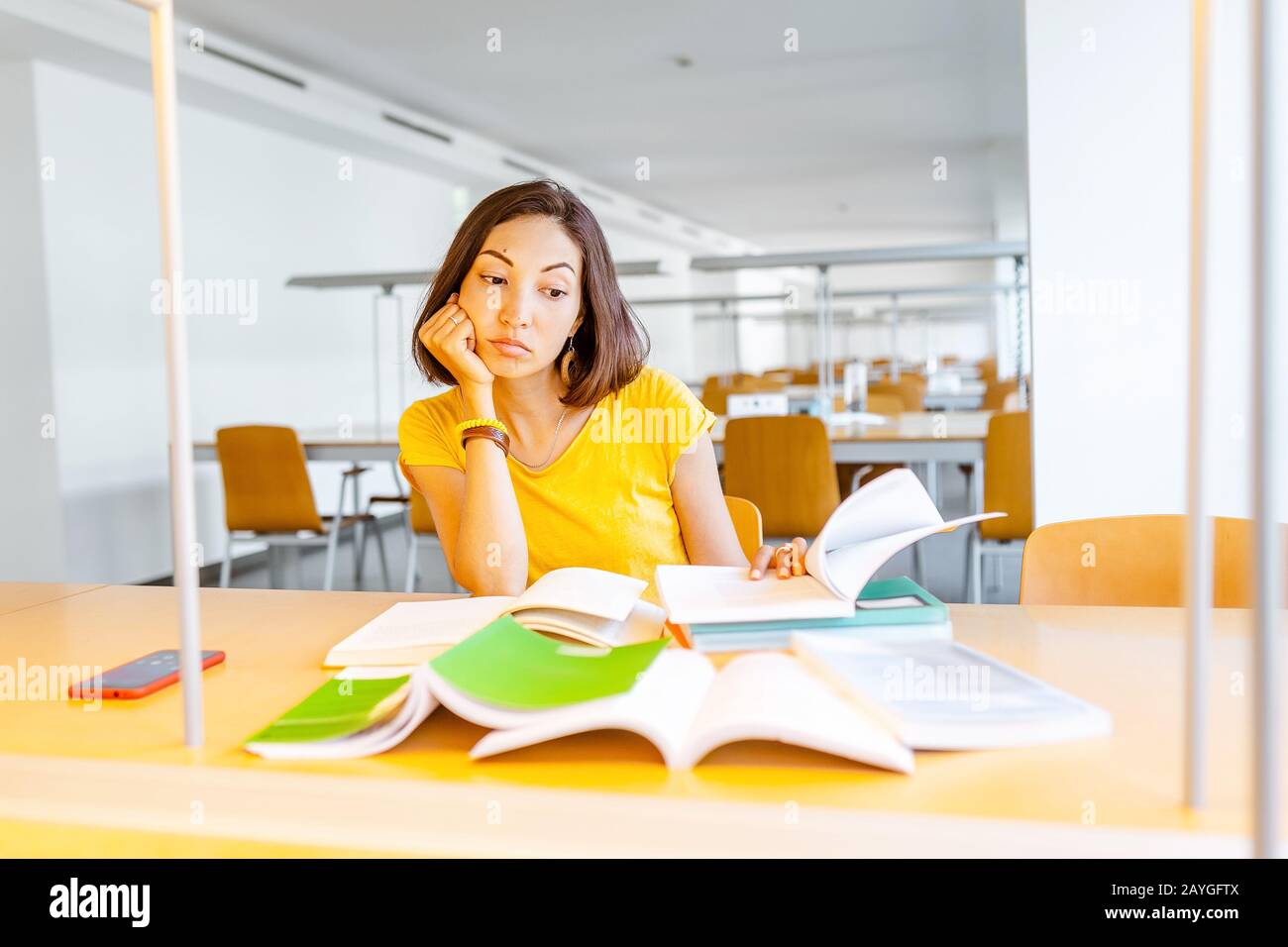 Sad and tired girl student doing homework in class Stock Photo - Alamy