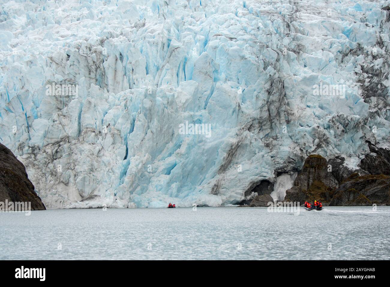 Zodiacs with tourists cruising in front of the Condor Glacier in the ...